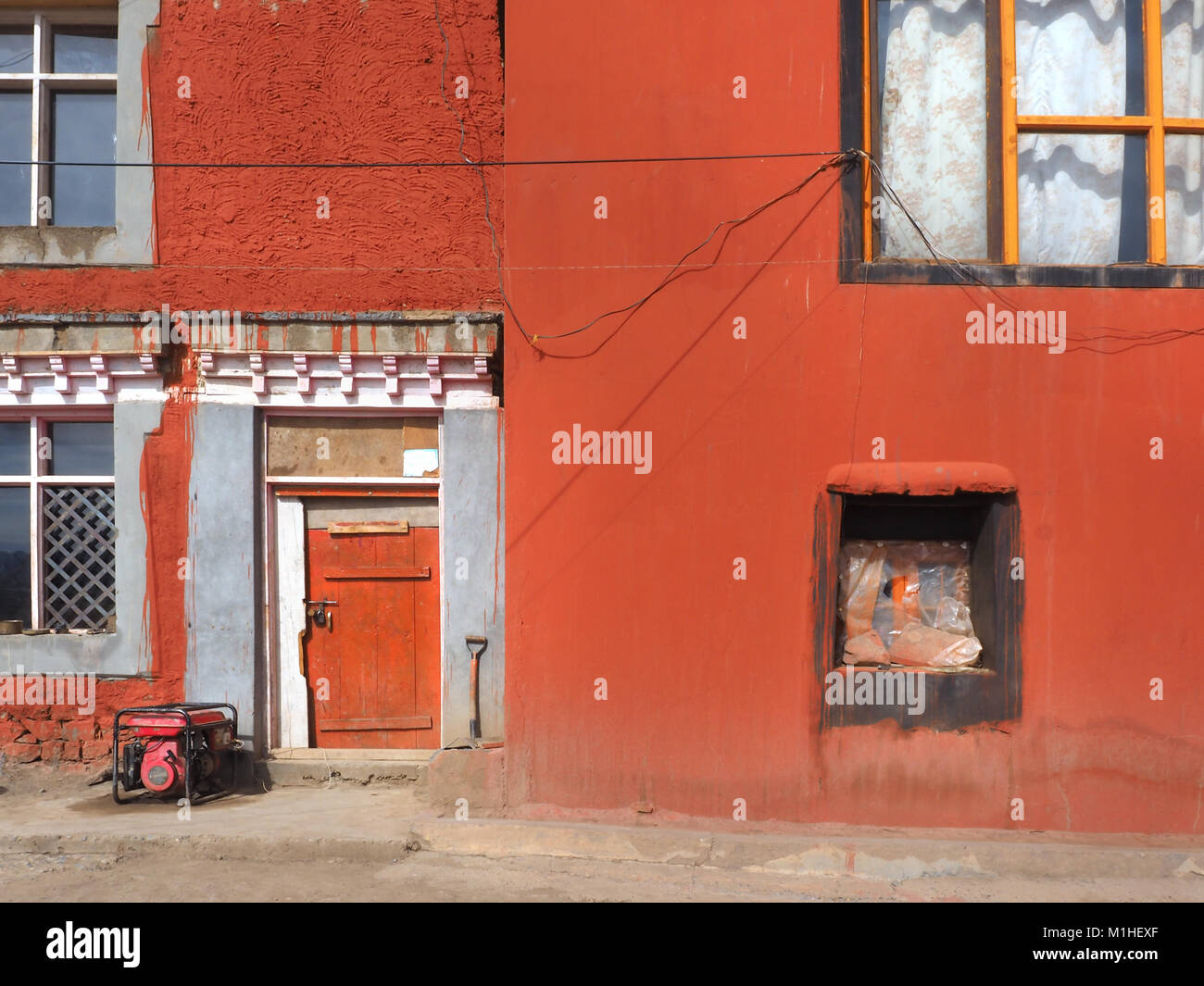 Red wall of old clay house with vintage wooden window frames, wooden ...