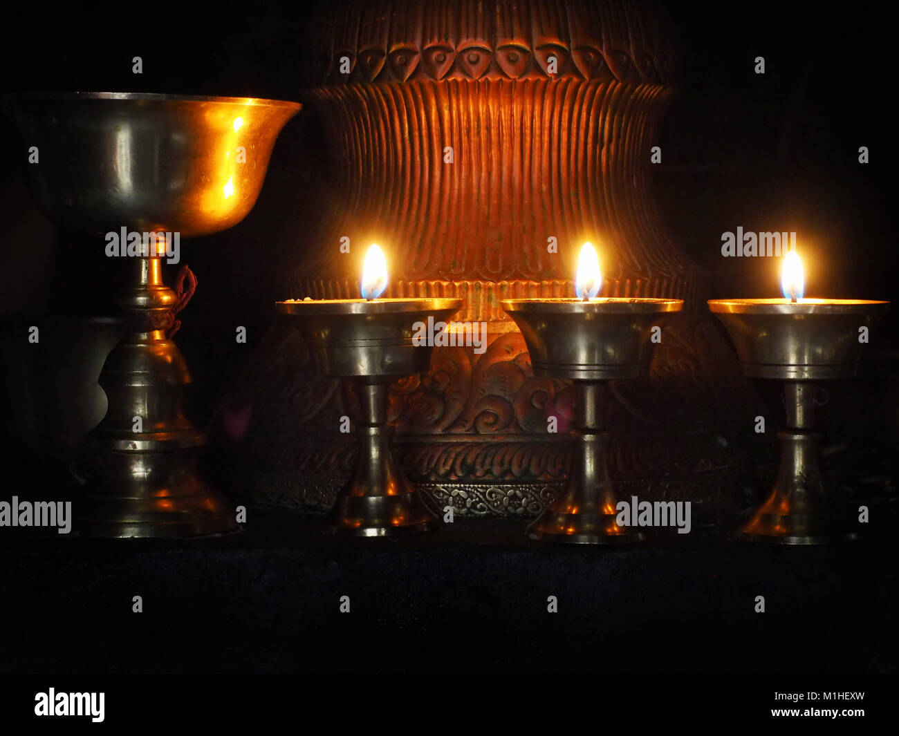 Large ancient metal prayerful Tibetan oil lamps with lights in the dark ...