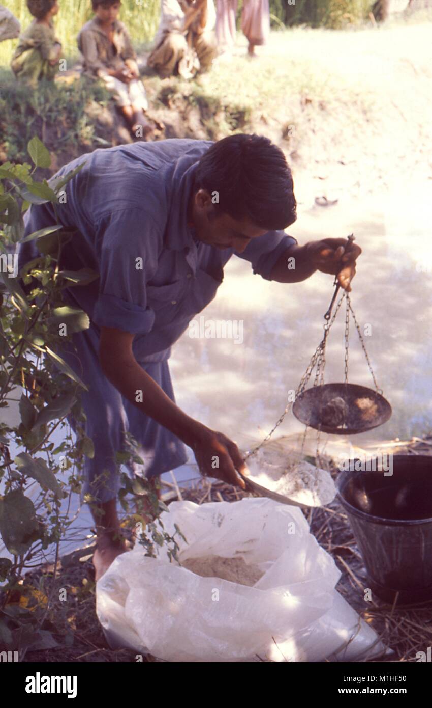 Photograph of a malaria control worker measuring the insecticide ...