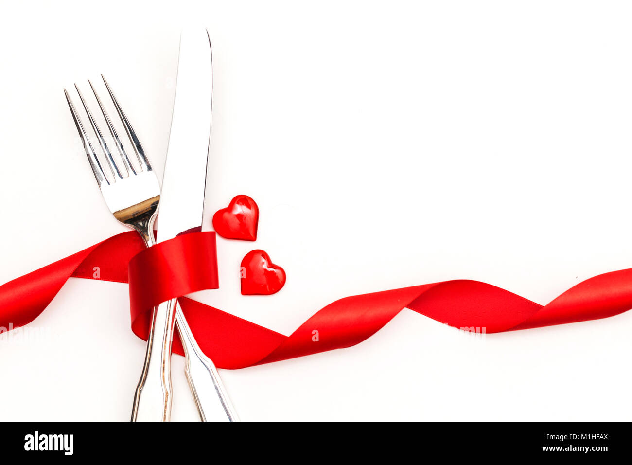 Valentine's day meal concept. knife and fork with red ribbon and love ...