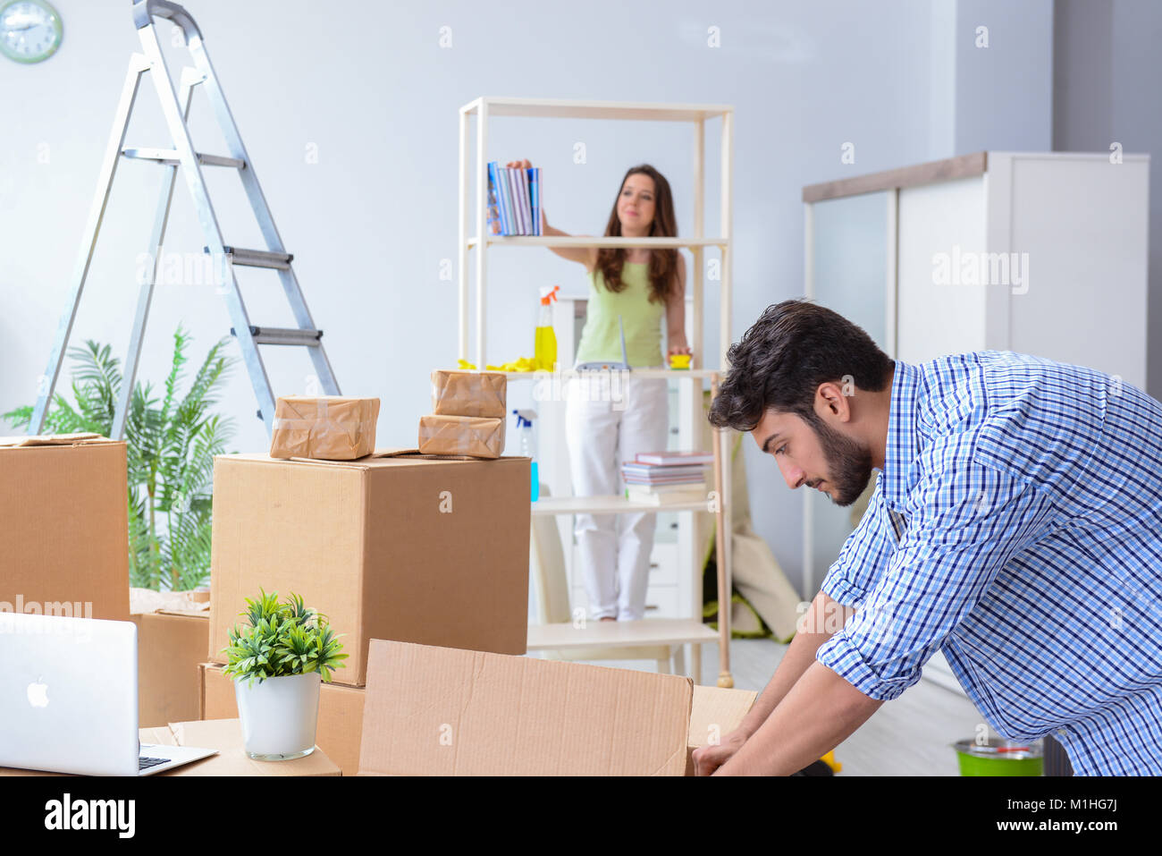 Young family unpacking at new house with boxes Stock Photo - Alamy
