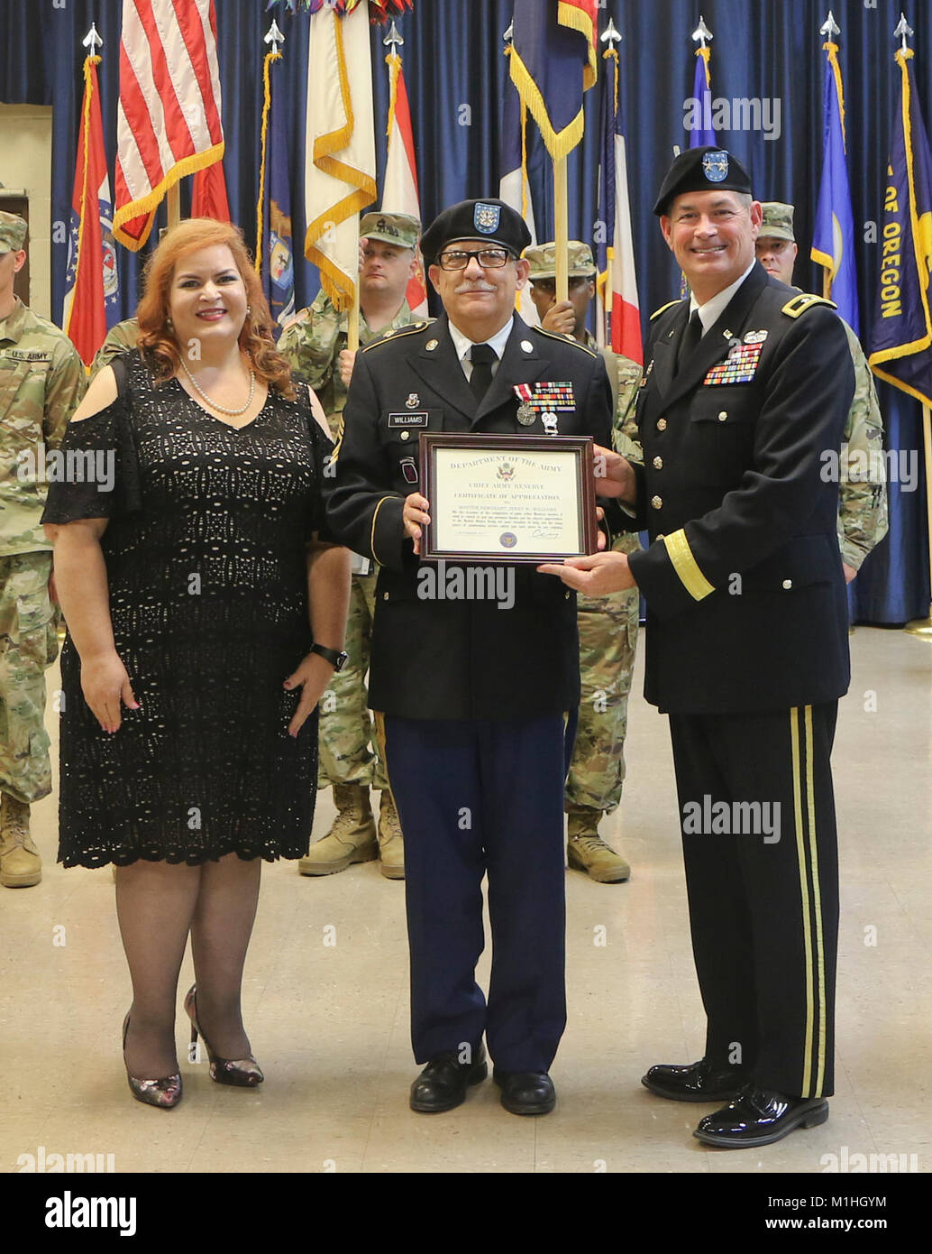 Retiree Msg. Jerry Williams is congratulated with a certificate of ...