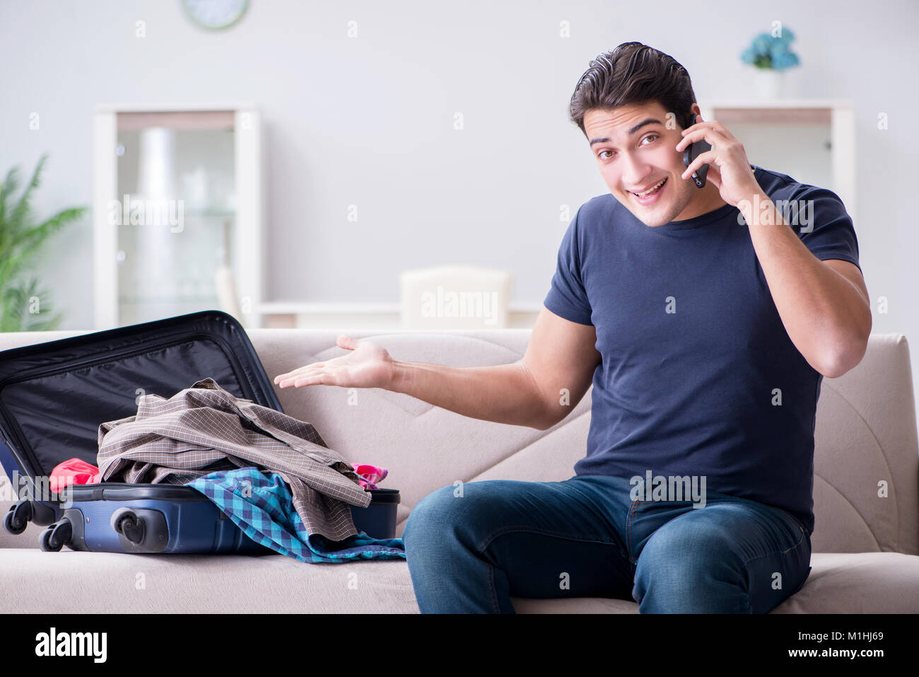Young man preparing packing for summer vacation Stock Photo - Alamy