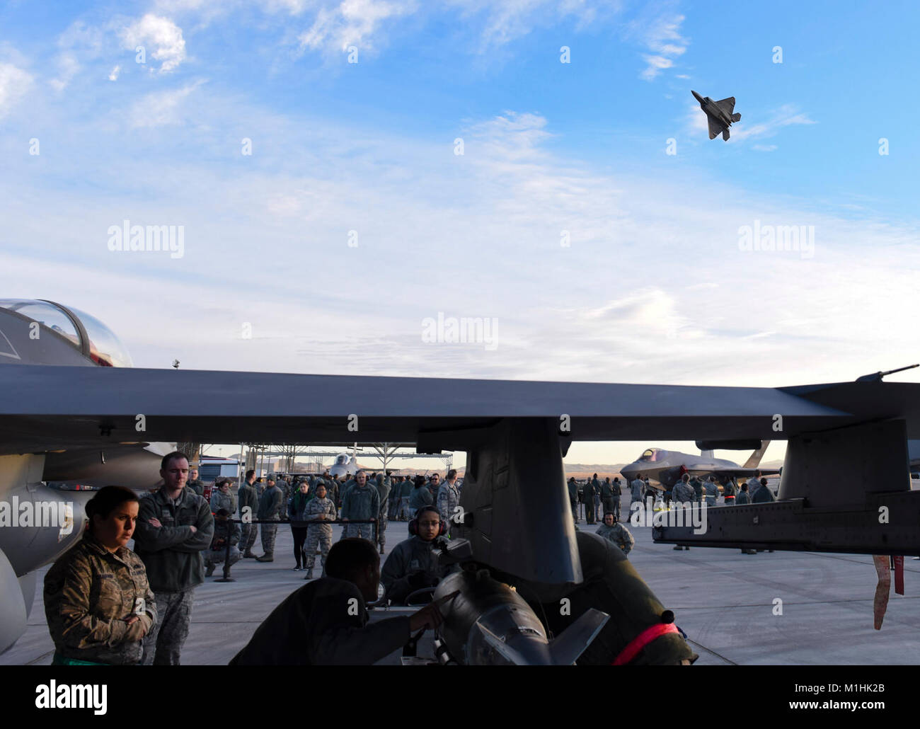 An F-22 Raptor fighter jet passes over the quarterly load crew ...