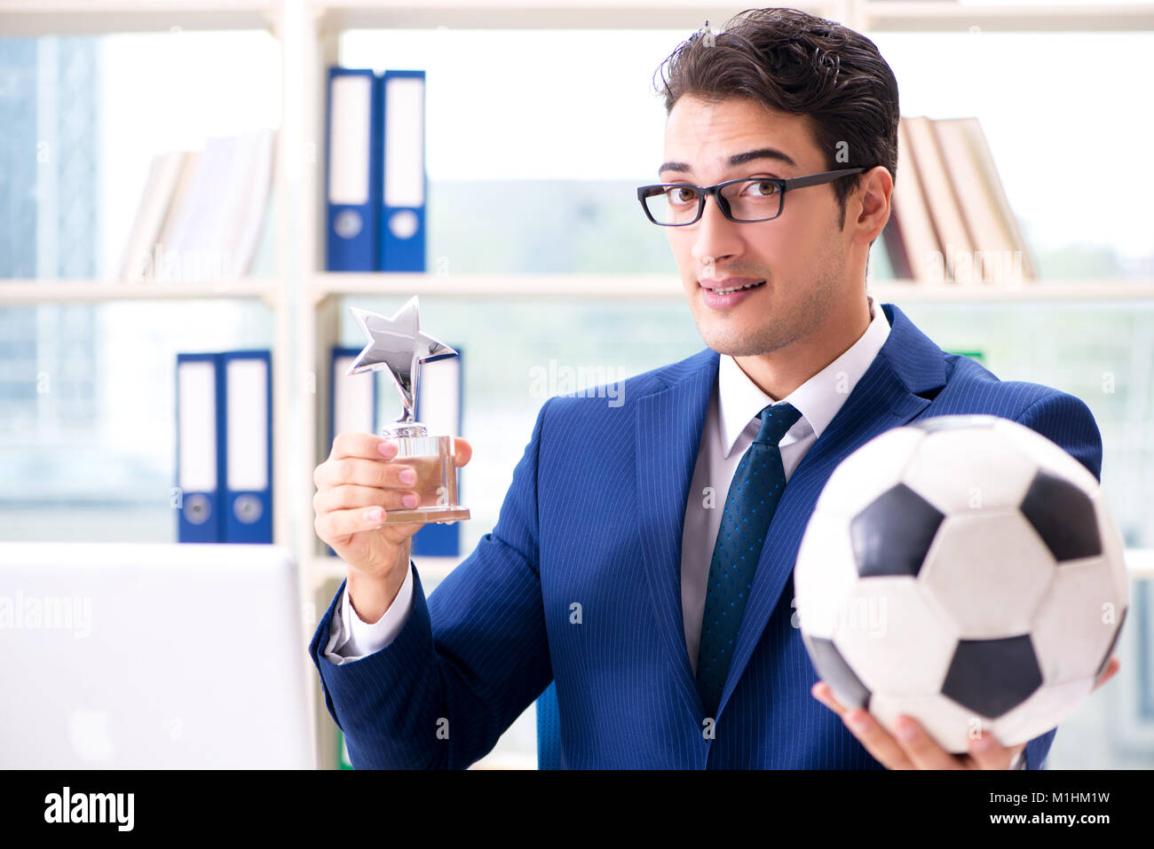 Businessman playing football in office hi-res stock photography and ...