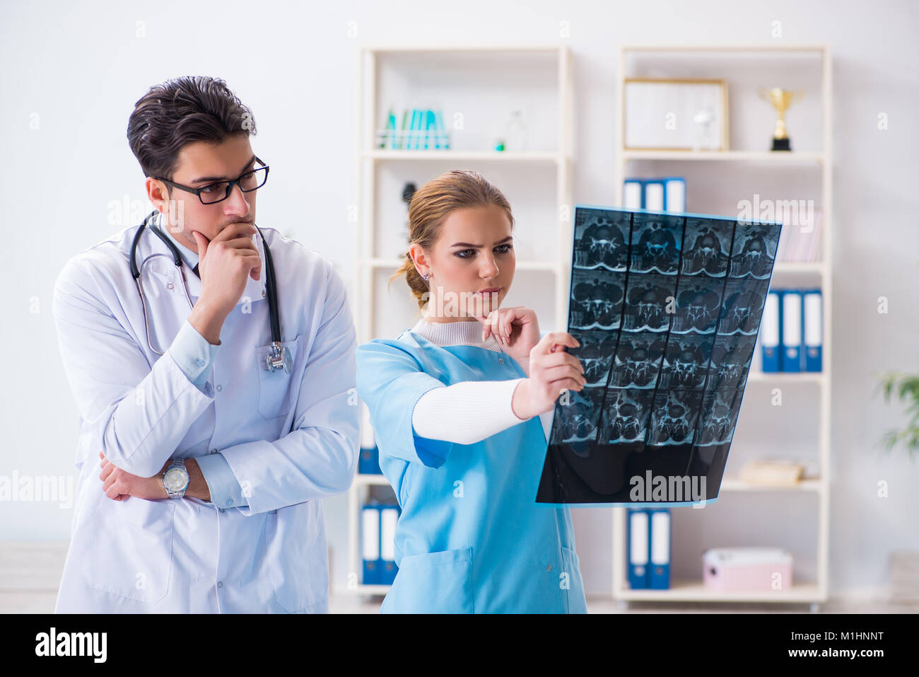 Two doctors examining x-ray images of patient for diagnosis Stock Photo ...