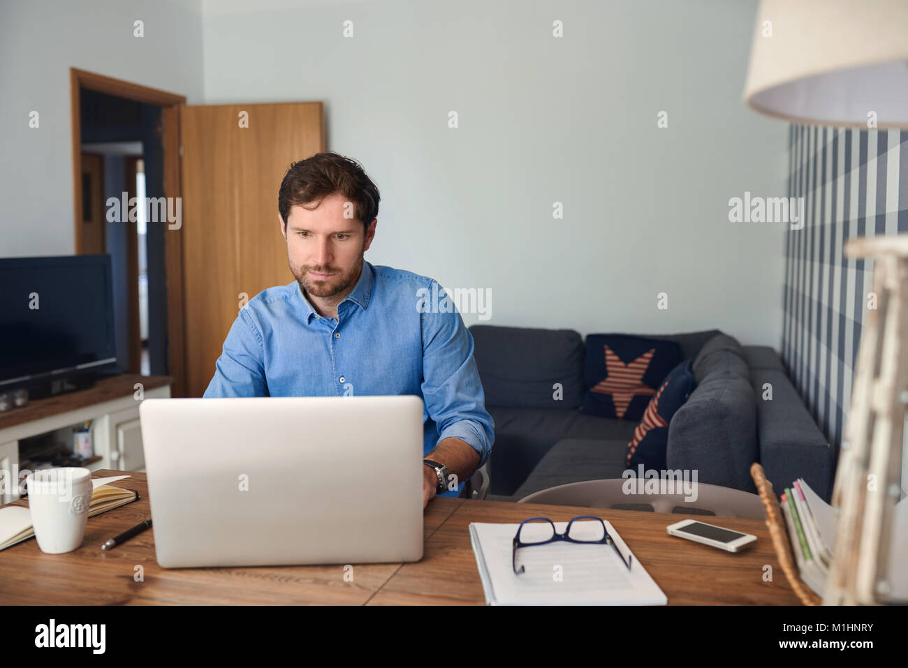 Young man working from home on a laptop Stock Photo - Alamy
