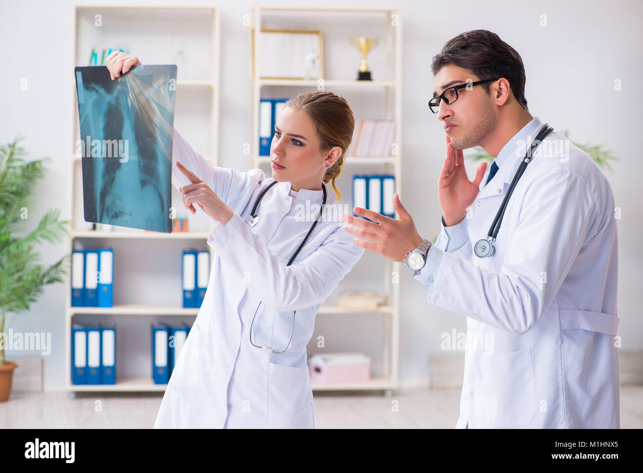 Two doctors examining x-ray images of patient for diagnosis Stock Photo ...