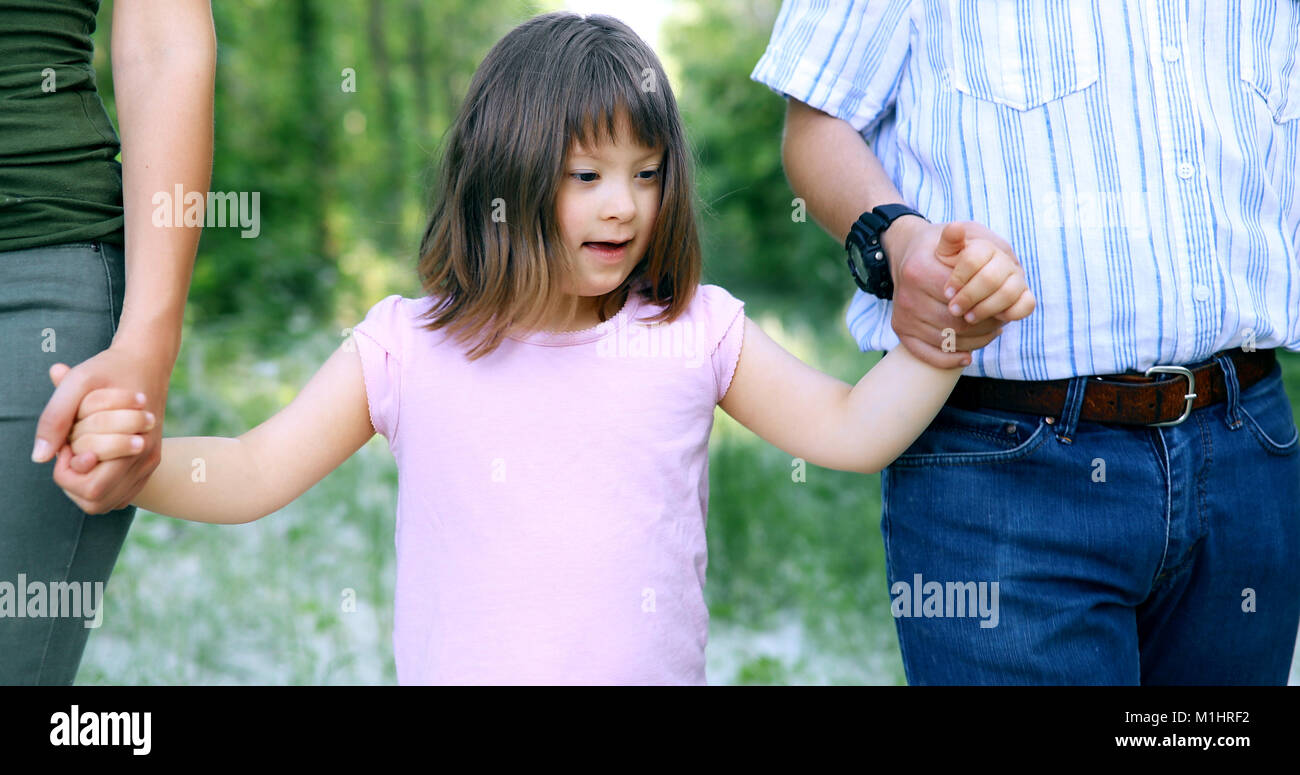 Beautiful little girl with down syndrome walking with parents Stock ...
