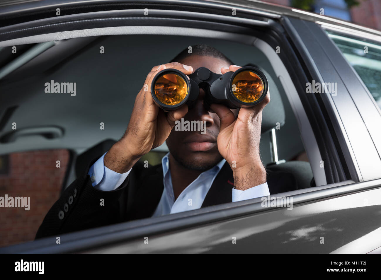 Close-up Of An African Man Sitting Inside Car Looking Through Binocular ...