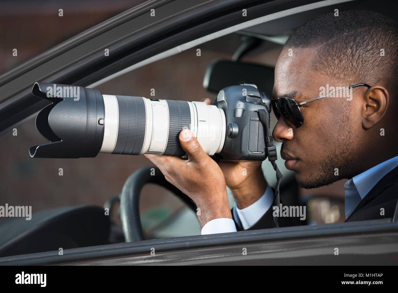 Private Detective Sitting Inside Car Photographing With SLR Camera ...
