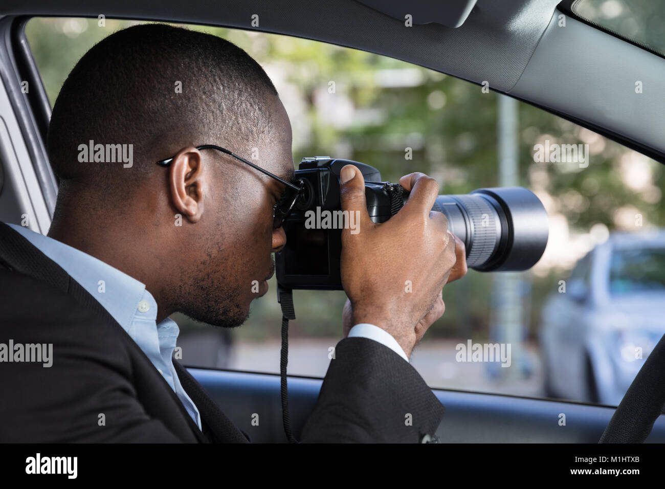Side View Of A Private Detective Sitting Inside Car Photographing With ...
