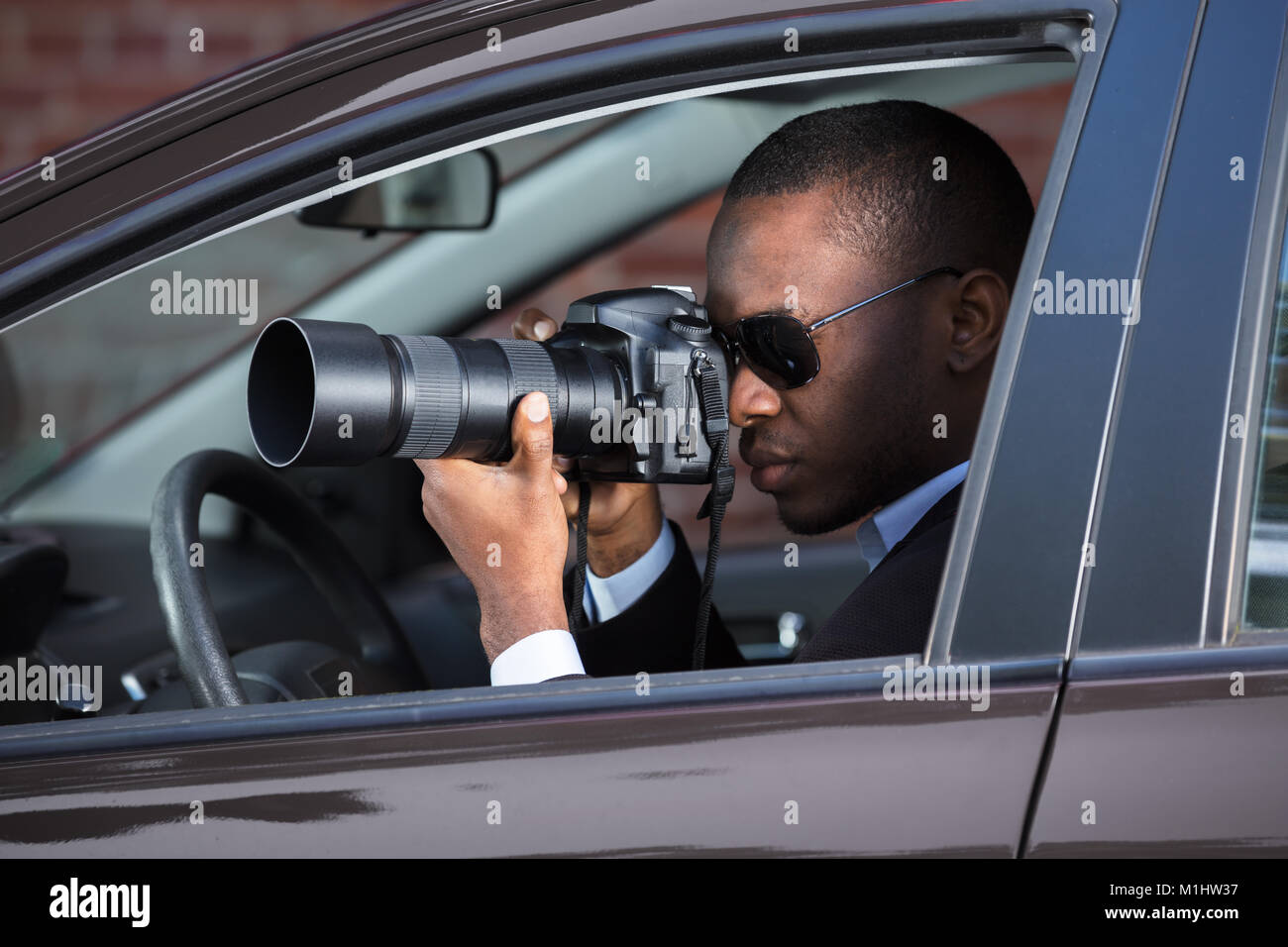 Private Detective Sitting Inside Car Photographing With SLR Camera ...