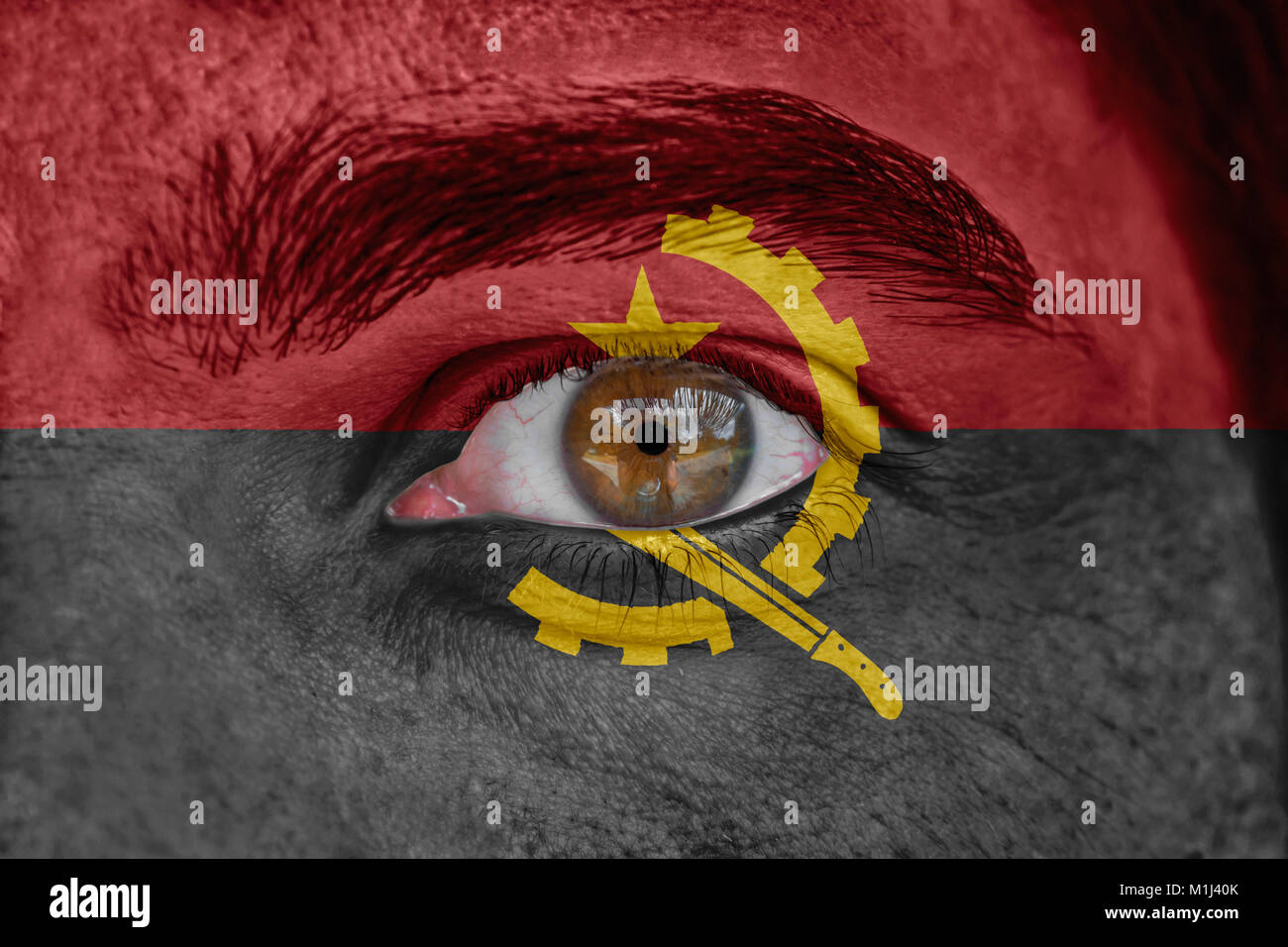 Human face and eye painted with flag of Angola Stock Photo - Alamy
