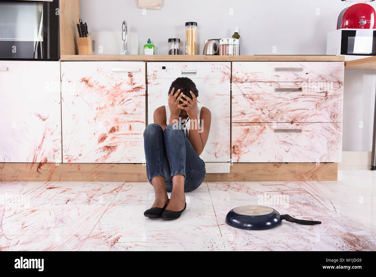 Disappointed African Woman Sitting On Kitchen Floor With Spilled Food ...
