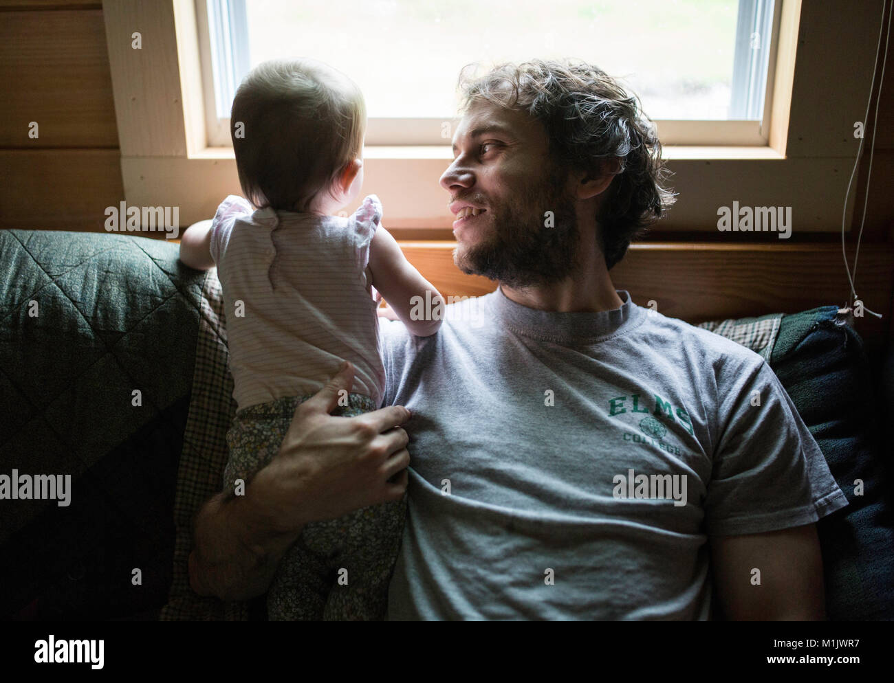 Father Smiling at Child on Couch Stock Photo - Alamy