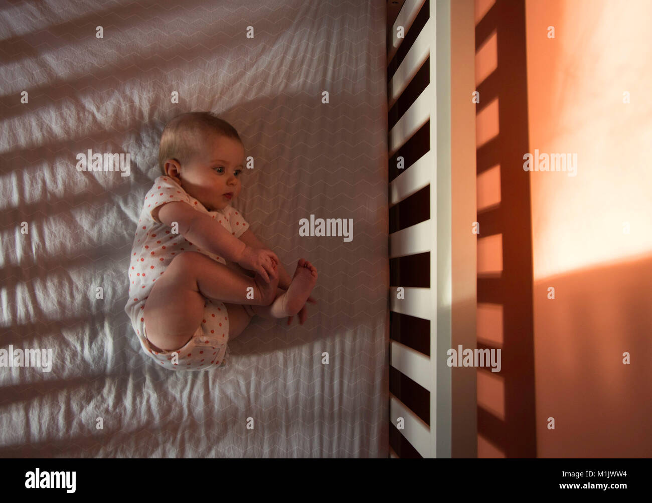 High Angle View of Baby Laying in Crib with Afternoon Light Stock Photo ...