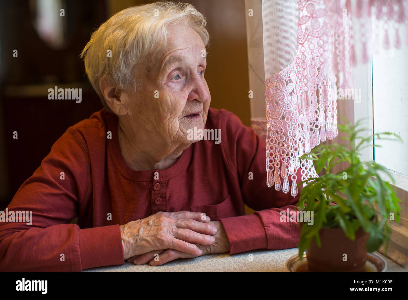 Mature woman looks out window hi-res stock photography and images - Alamy