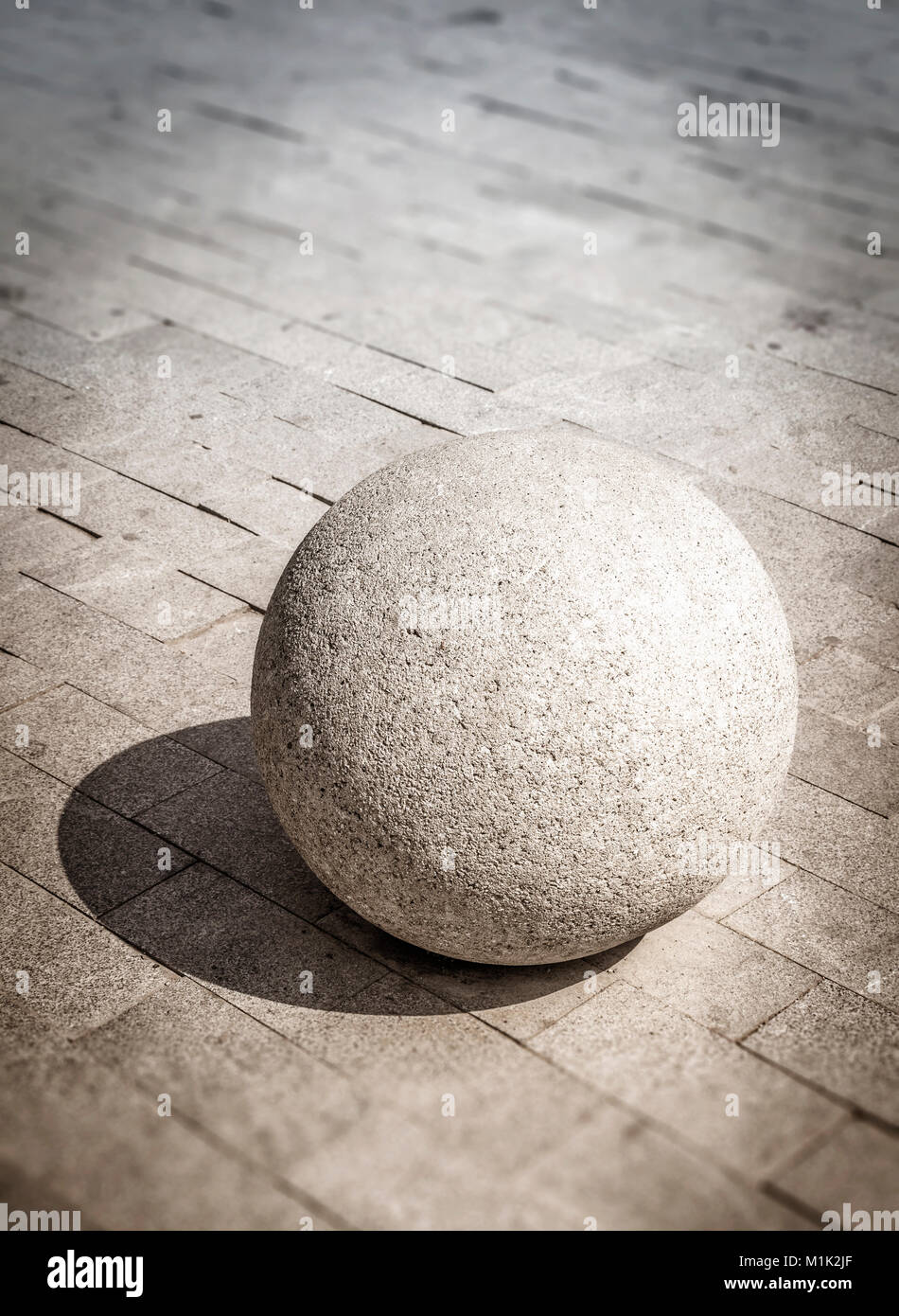 A large stone ball lies on a stone pavement Stock Photo - Alamy