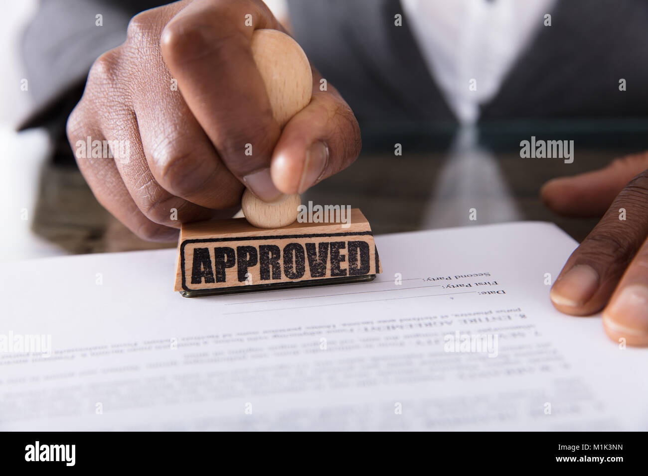 Close-up Of A Person's Hand Stamping On Approved Contract Form On Desk ...