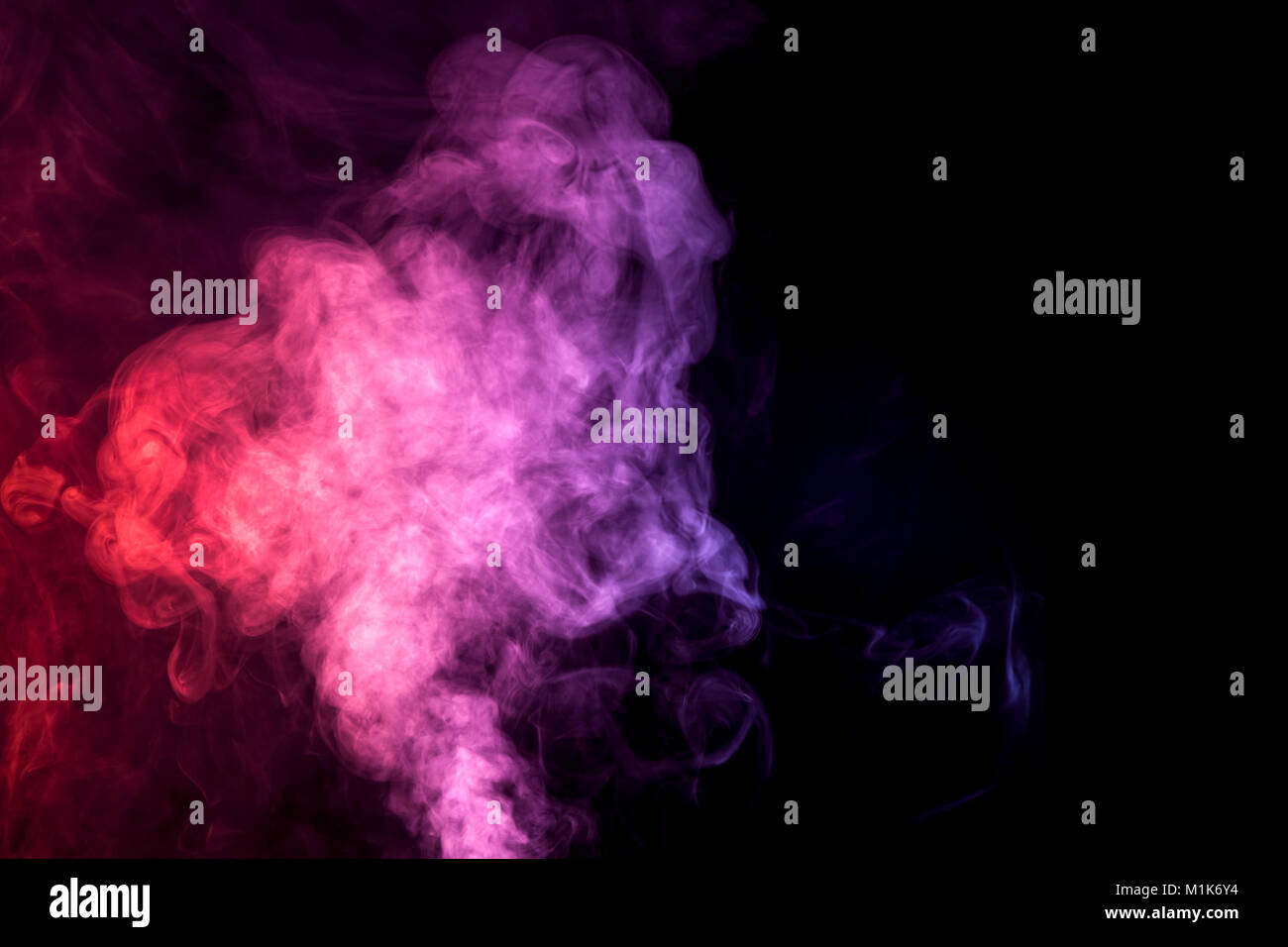 Colorful red and pink smoke clouds on dark background.Background of ...