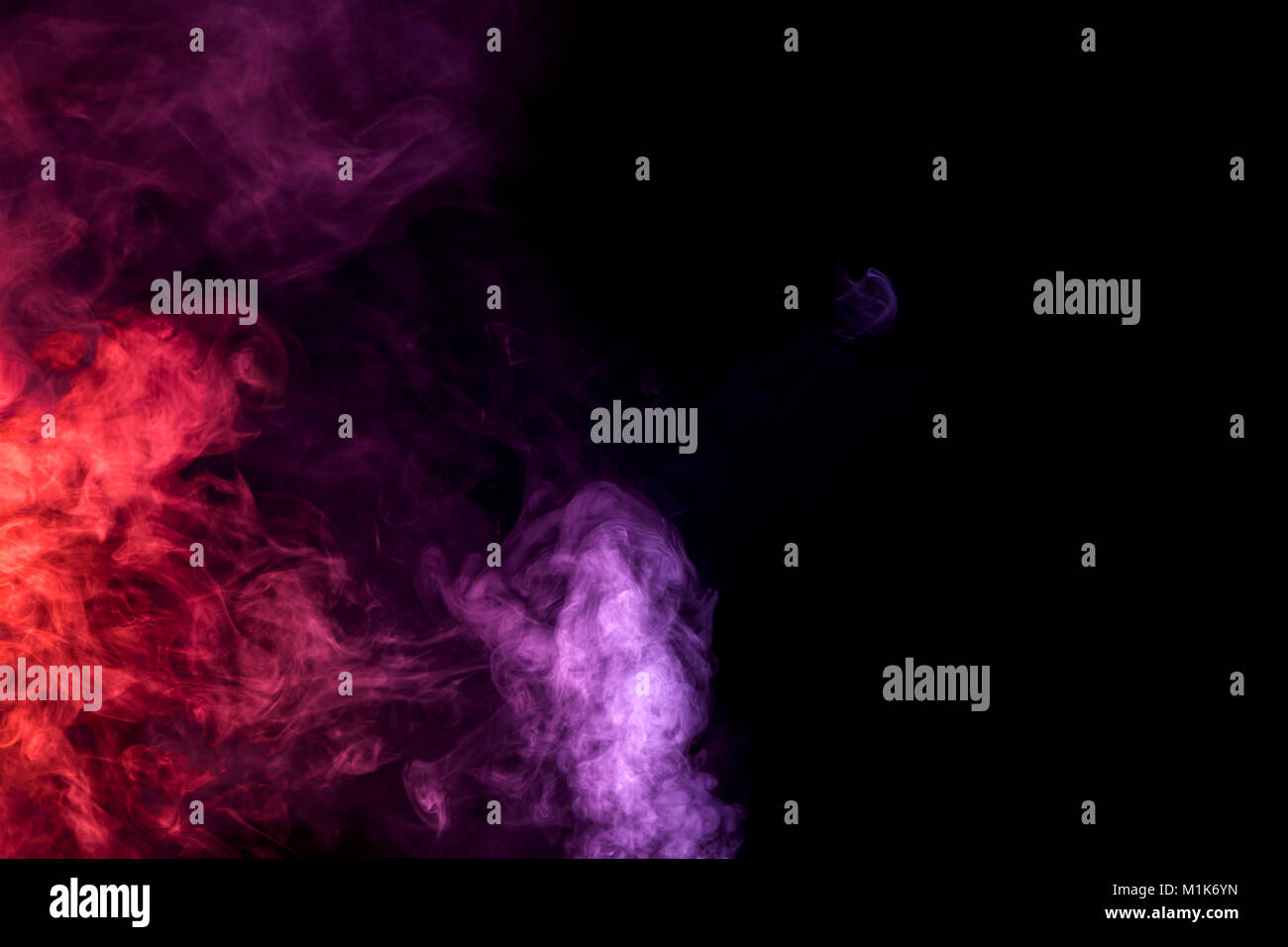 Colorful pink and red smoke clouds on dark background.Background of ...