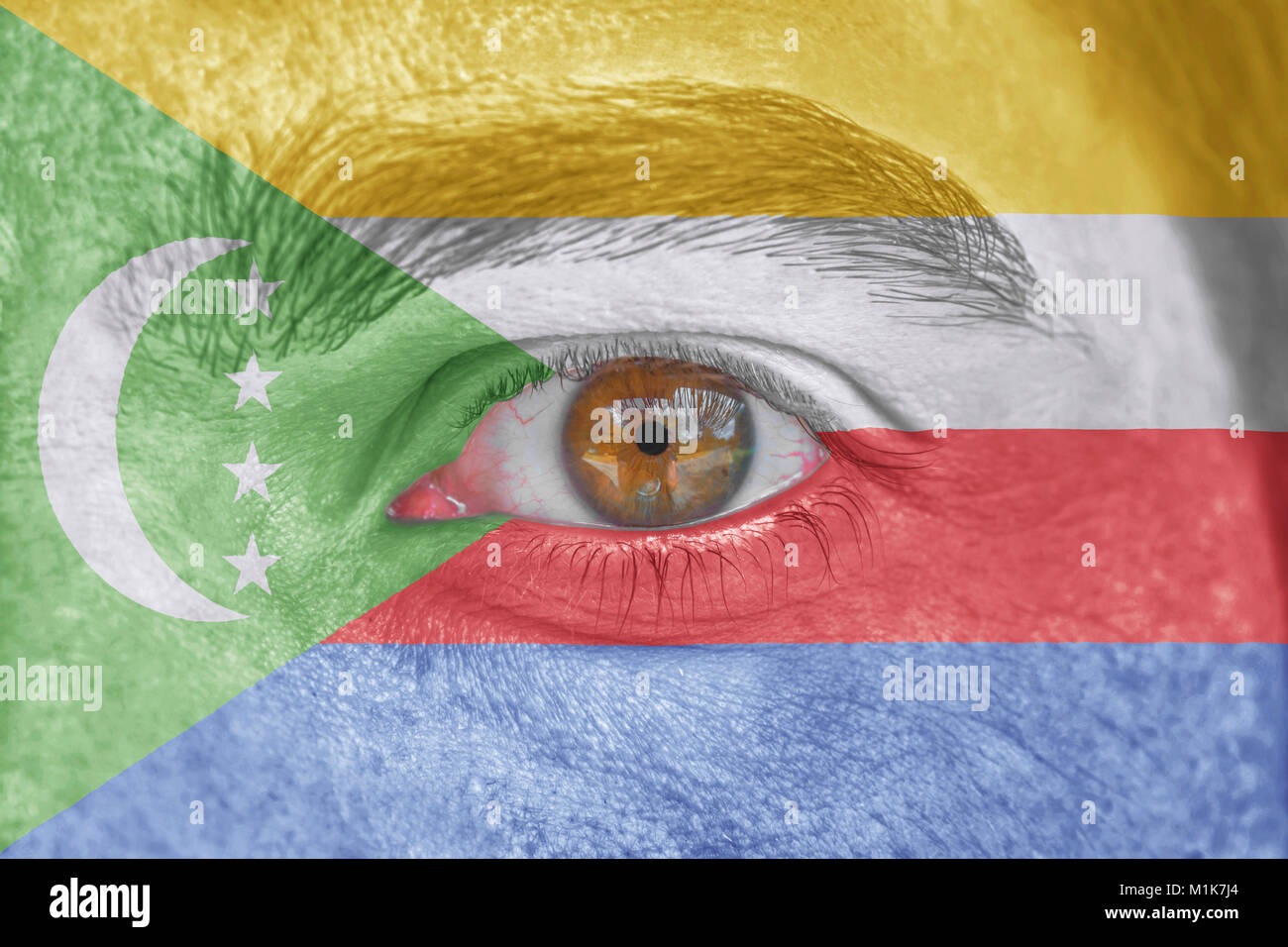 Human face and eye painted with flag of Comoros Stock Photo - Alamy