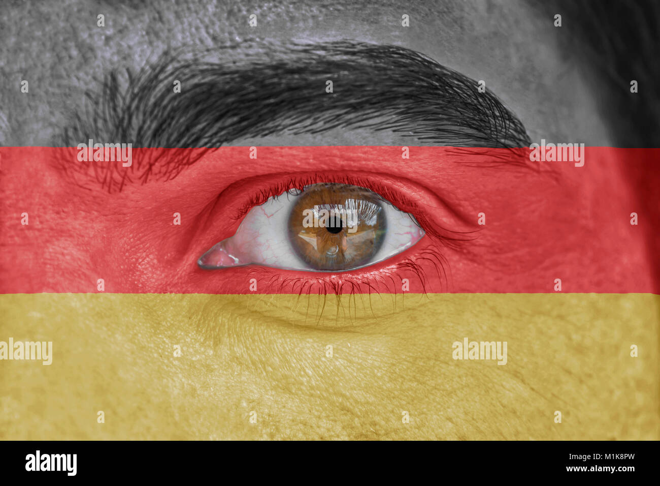 Human face and eye painted with flag of Germany Stock Photo - Alamy