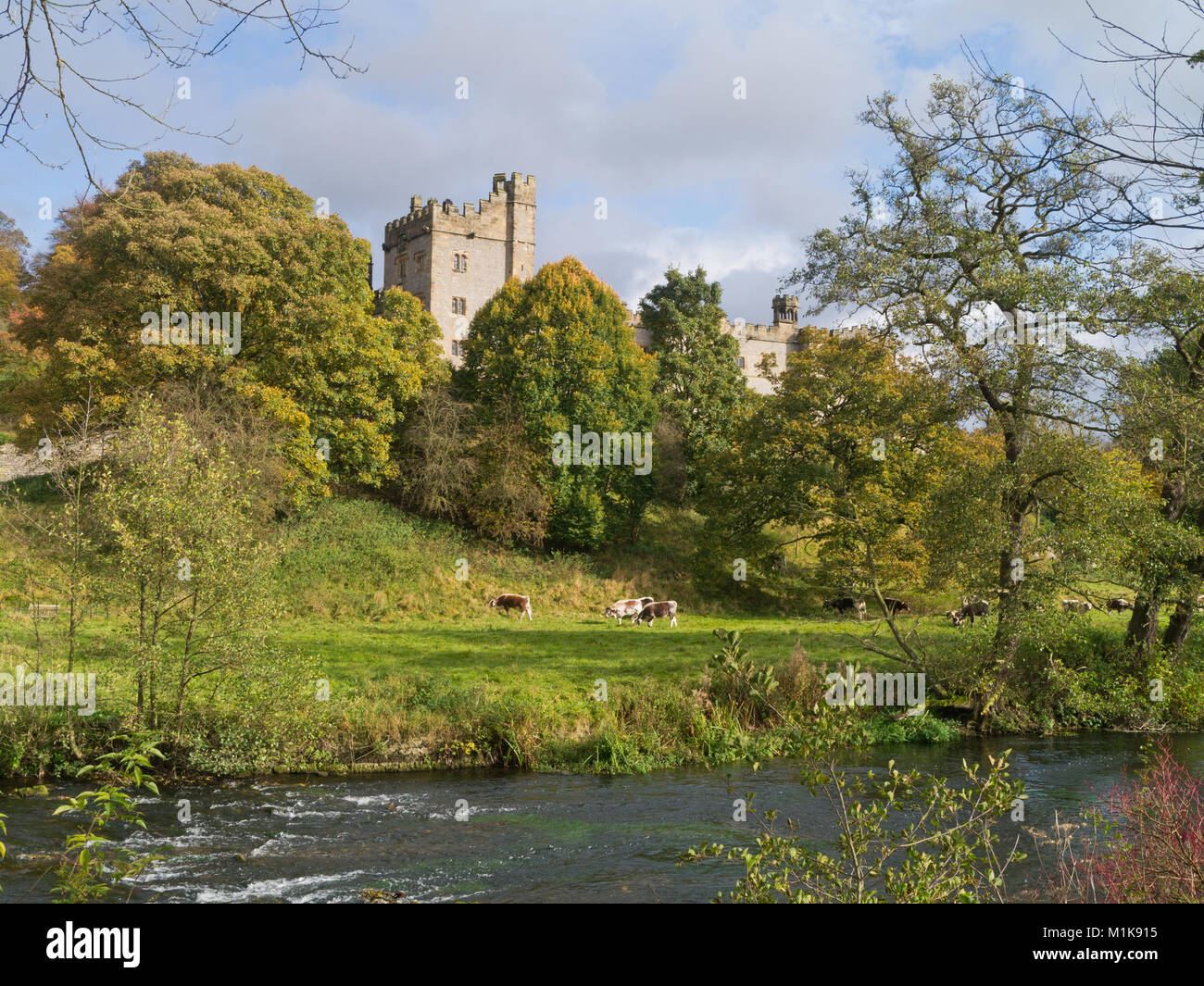 A glimpse of Haddon Hall through surrounding trees with the River Wye ...