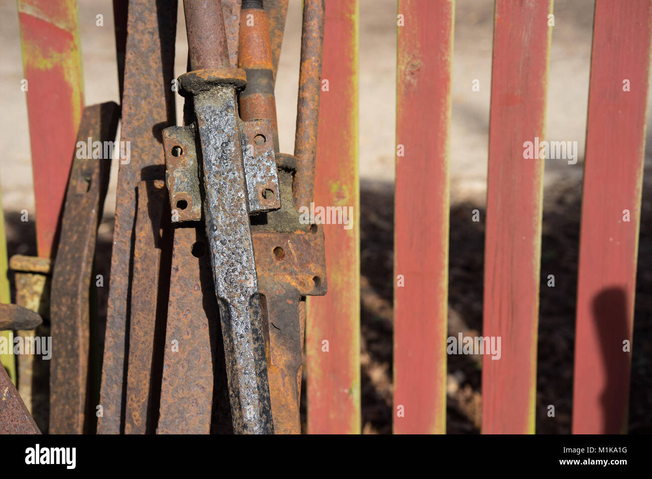 rusted iron leaning out of red painted stakit Stock Photo - Alamy