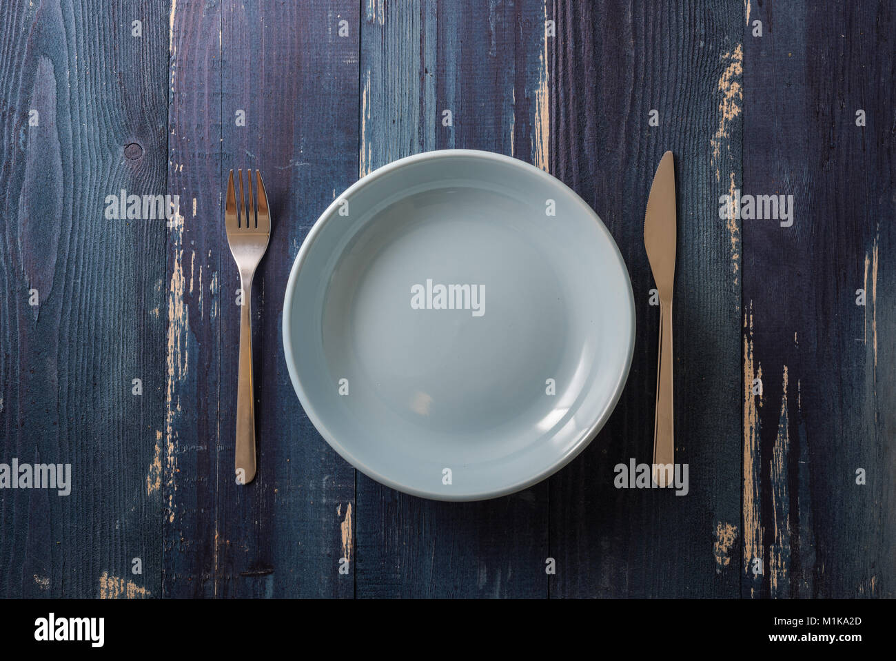 Blue Round Plate with utensils on ocean blue wooden table background ...