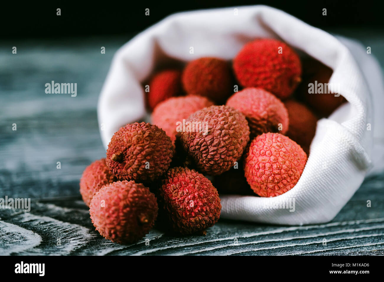 Lychee fruit in white sack close Stock Photo - Alamy