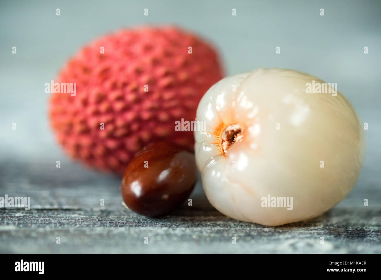 Two lychee fruits wooden background Stock Photo - Alamy
