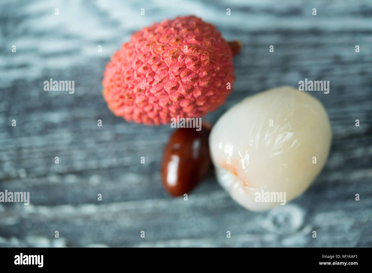 Two lychee fruits wooden background Stock Photo - Alamy