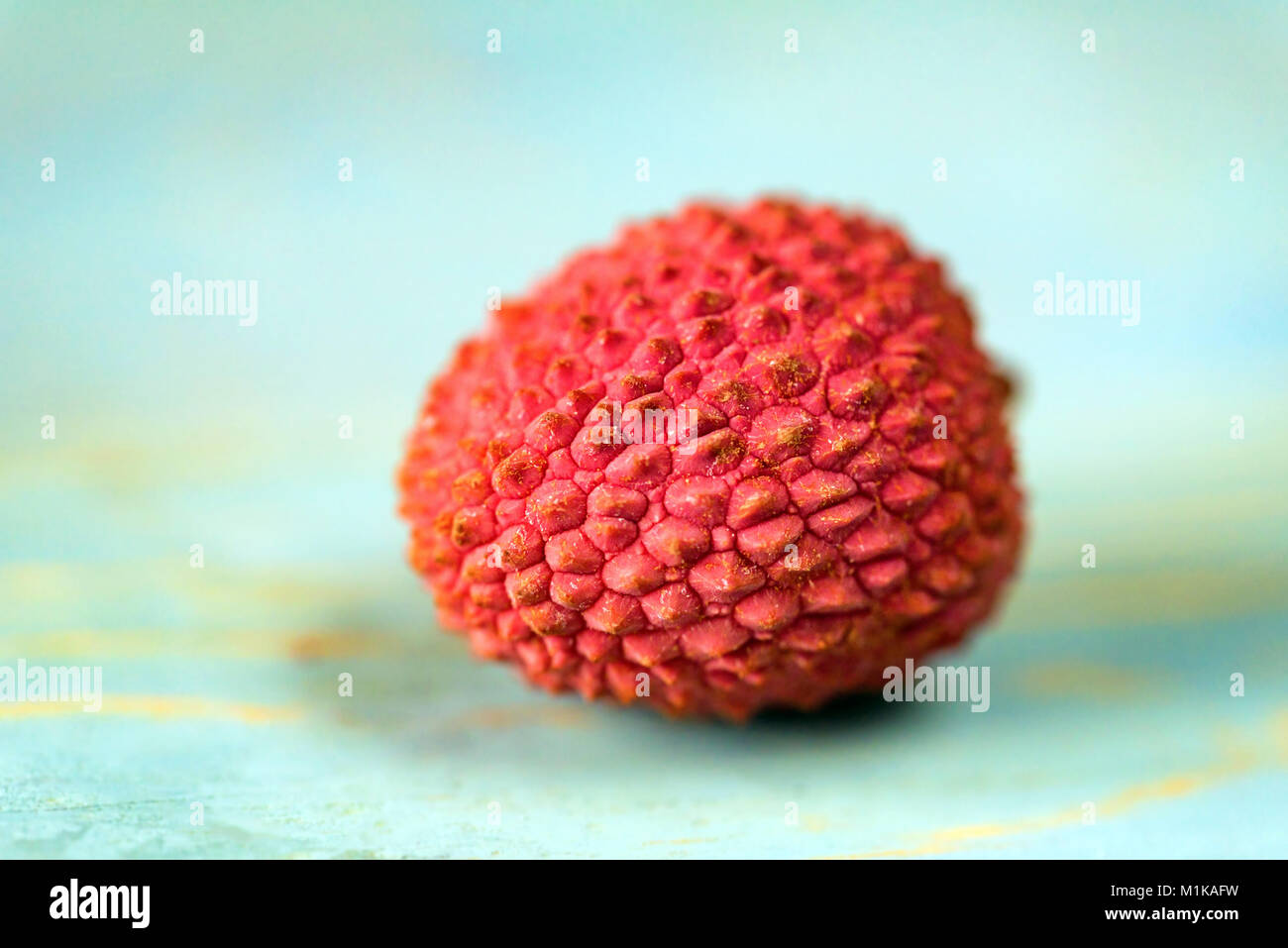 Single lychee on wooden background close Stock Photo - Alamy