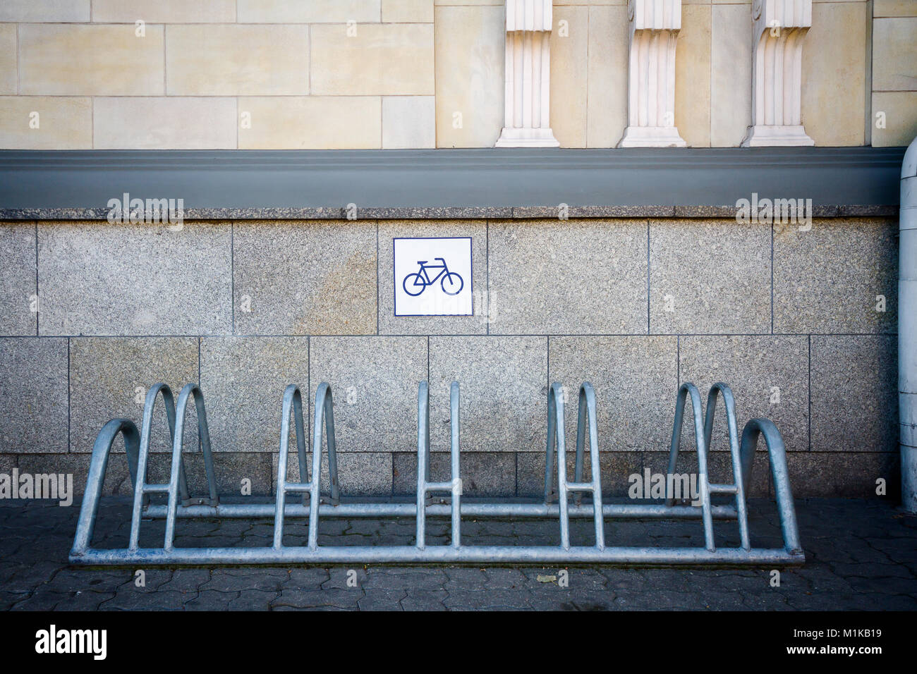 Metal bike rack by the tiled wall Stock Photo - Alamy