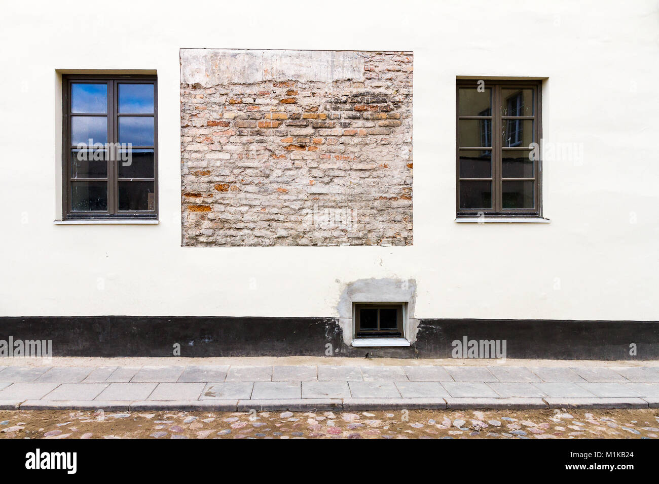 Modern white street wall with some small windows and example of old ...