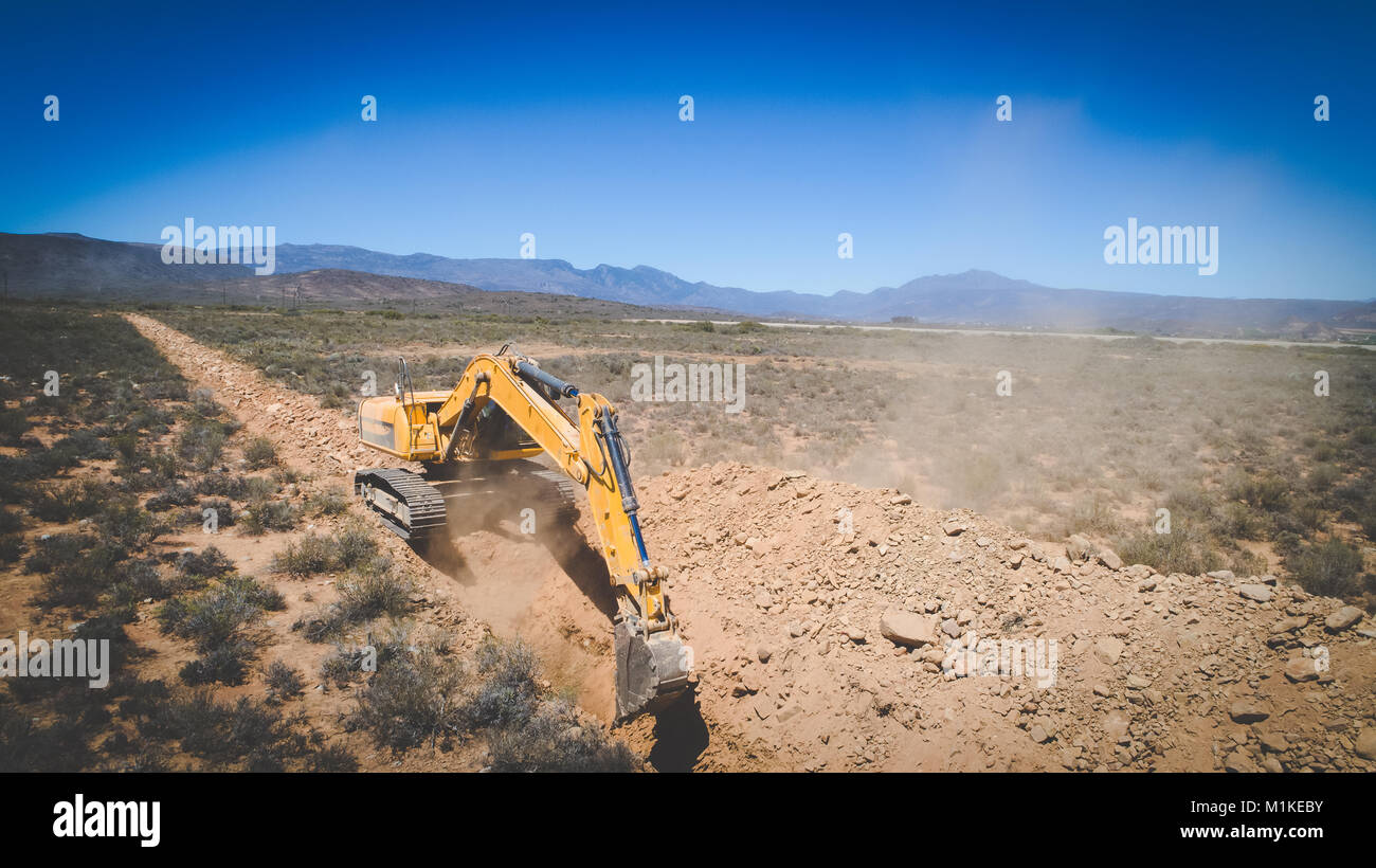 Aerial photo of earth moving machinery front loader digging a trench on ...