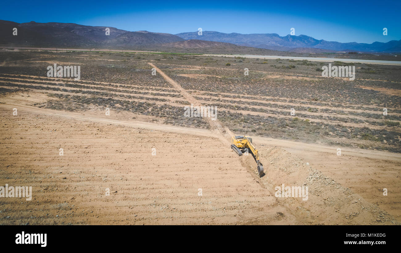 Aerial photo of earth moving machinery front loader digging a trench on ...