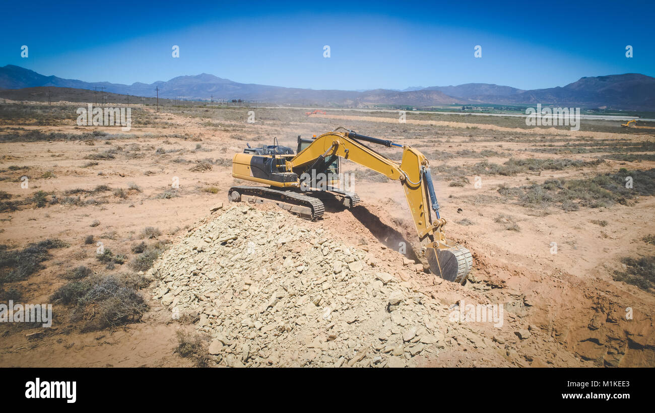 Aerial photo of earth moving machinery front loader digging a trench on ...