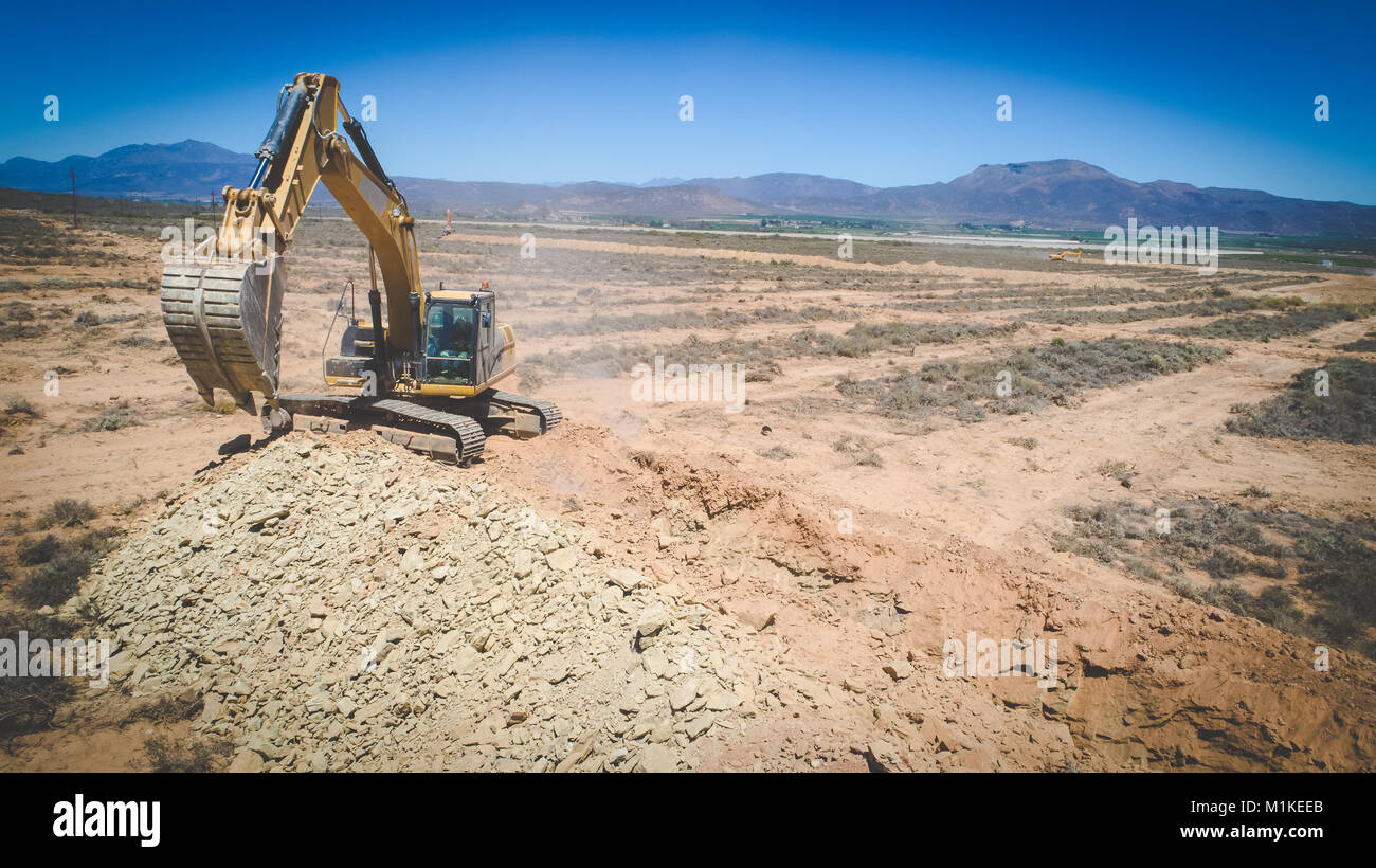 Aerial photo of earth moving machinery front loader digging a trench on ...