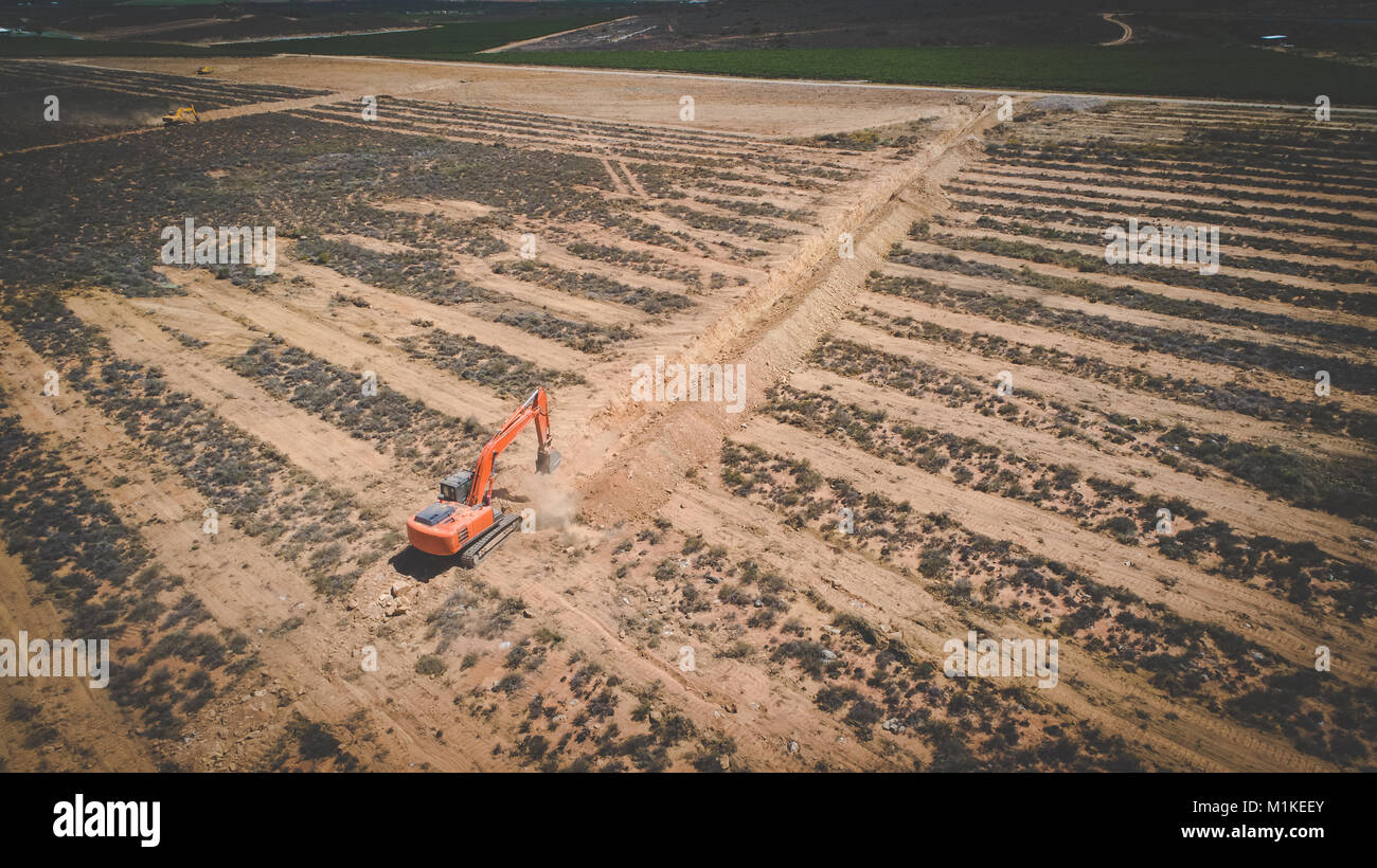 Aerial photo of earth moving machinery front loader digging a trench on ...