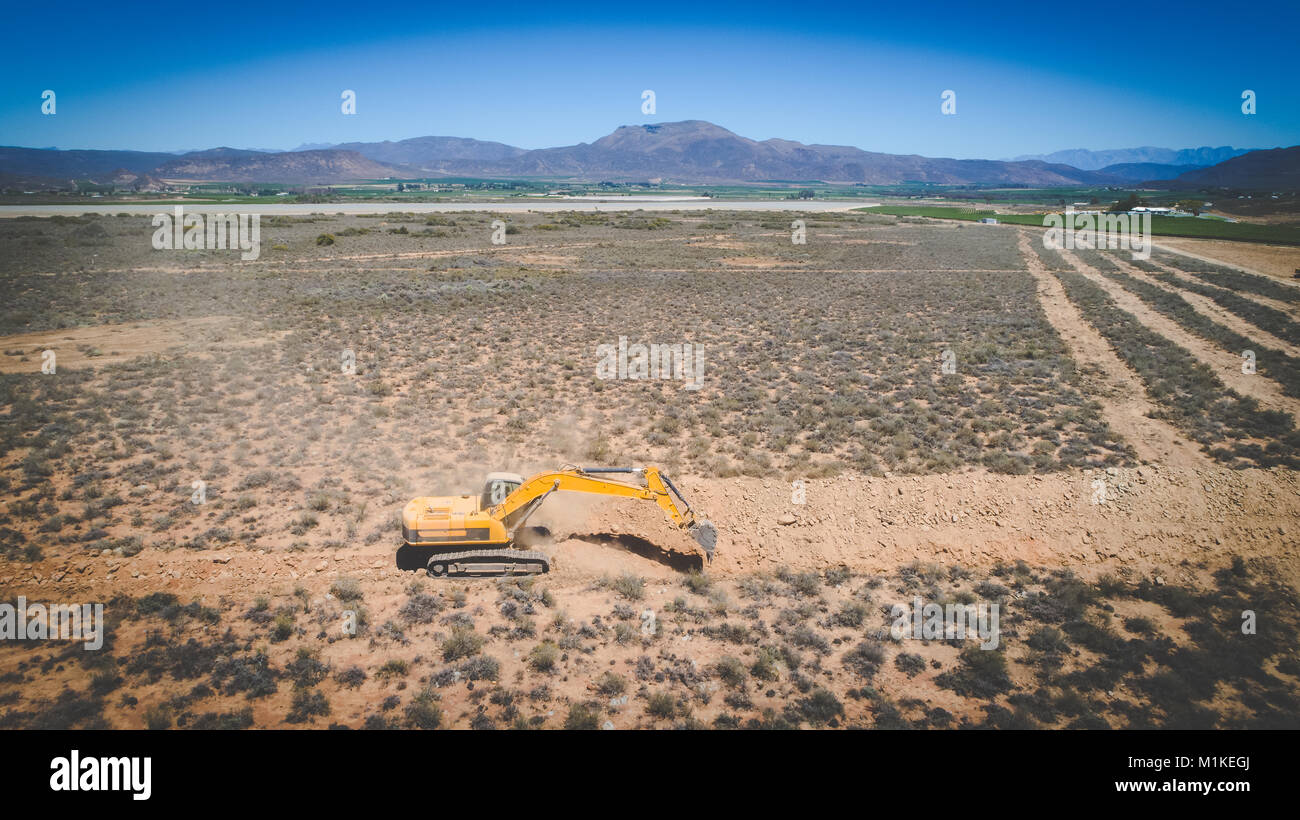 Aerial photo of earth moving machinery front loader digging a trench on ...