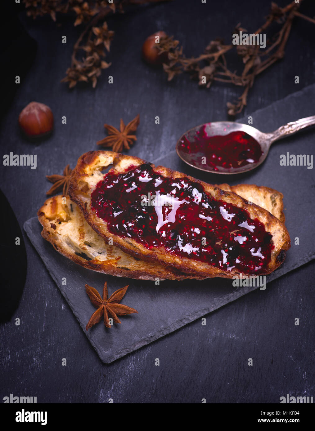 toast of white bread with raspberry jam on a black surface, top view ...