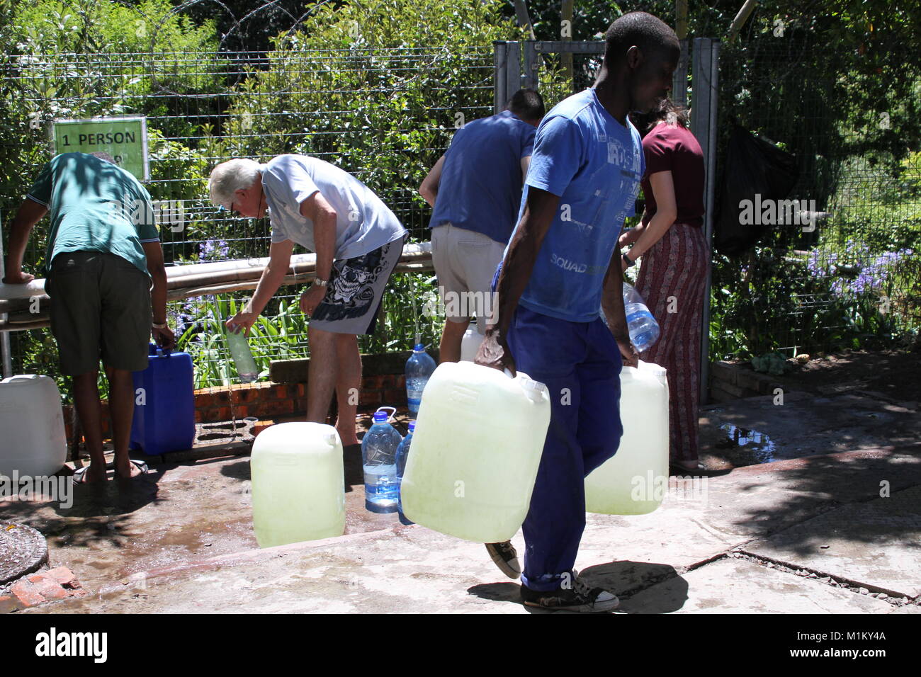 ARCHIVR - Citizens fill up water canisters at a natural spring in a ...