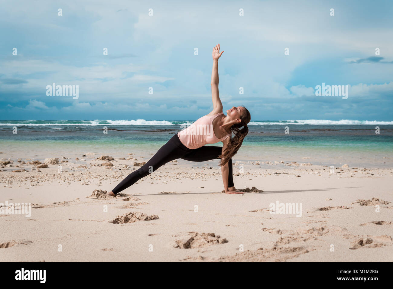 Yoga woman. Side angle pose asana. Ocean background Stock Photo - Alamy