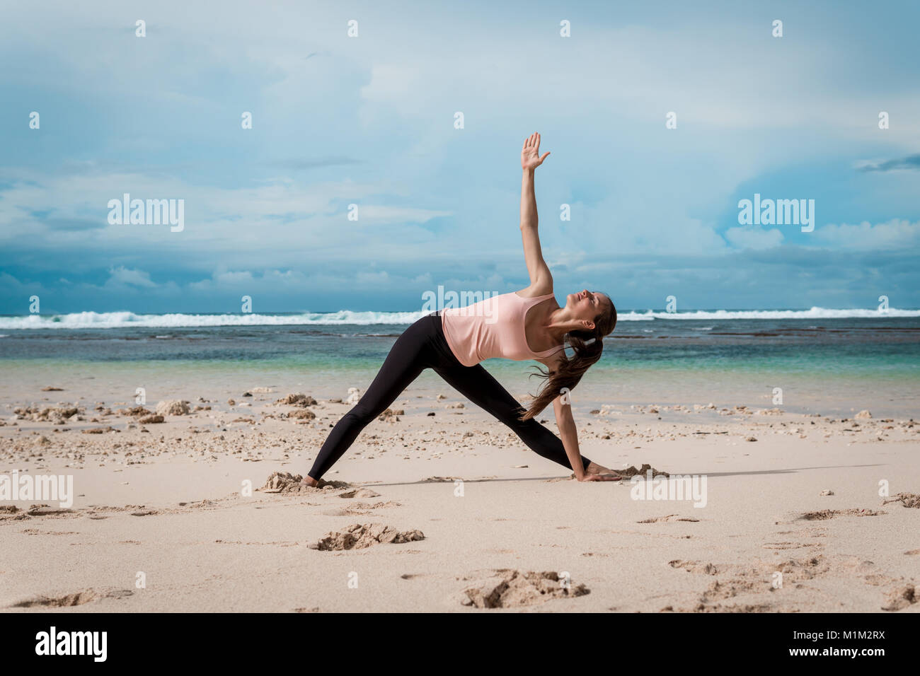 Yoga woman. Extended triangle pose asana. Ocean background Stock Photo ...