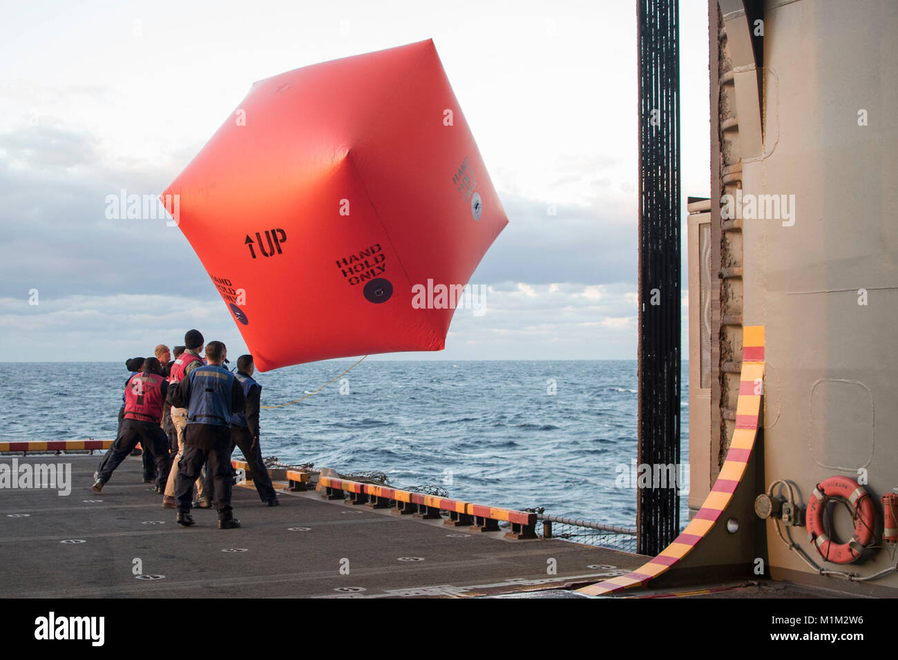 U.S. Navy sailors launch red inflatable baloon target prior to gunnery ...