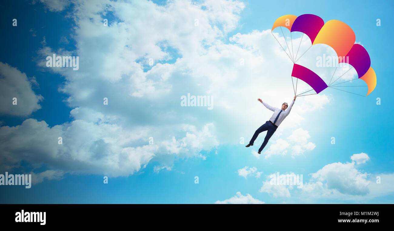 Young businessman falling on parachute in business concept Stock Photo ...