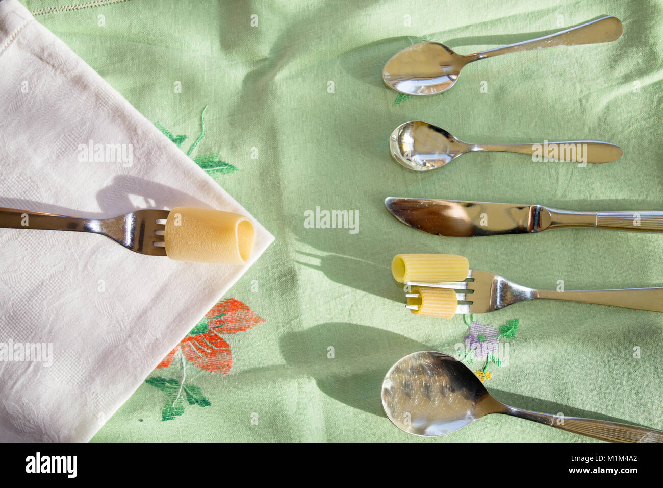 geometric composition with top view between raw pasta and silver ...